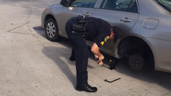 Caught on camera: Kind cop changing woman's flat tire | khou.com